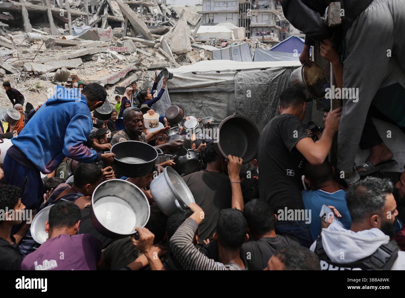 Palestinians struggle to get donated food at a community kitchen in ...