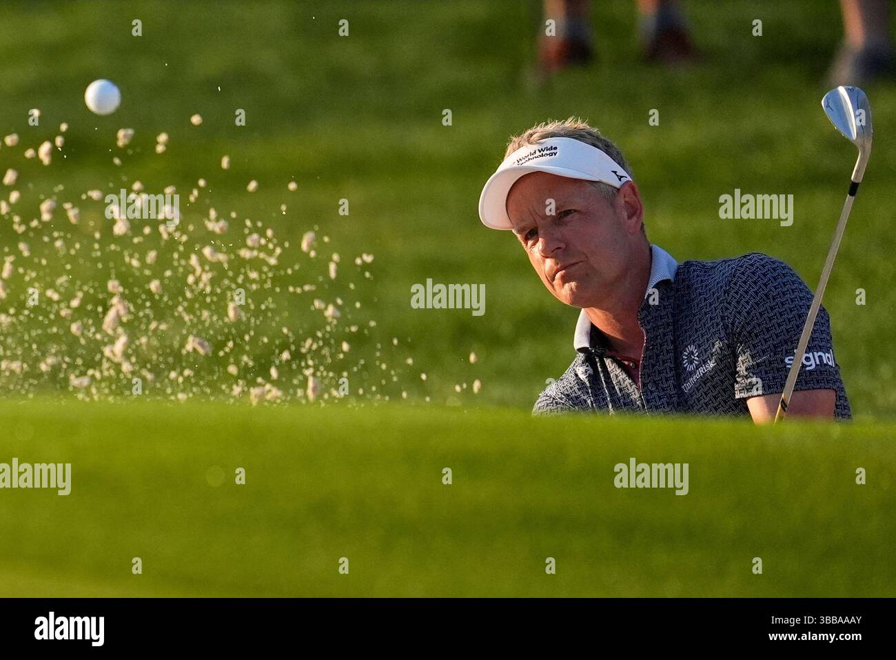 Luke Donald, of England, hits from the bunker on the first hole during ...