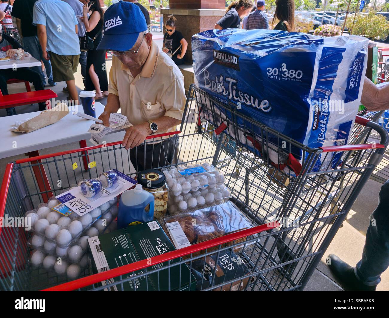 FILE - A customer checks his shopping receipts while waiting in line at ...