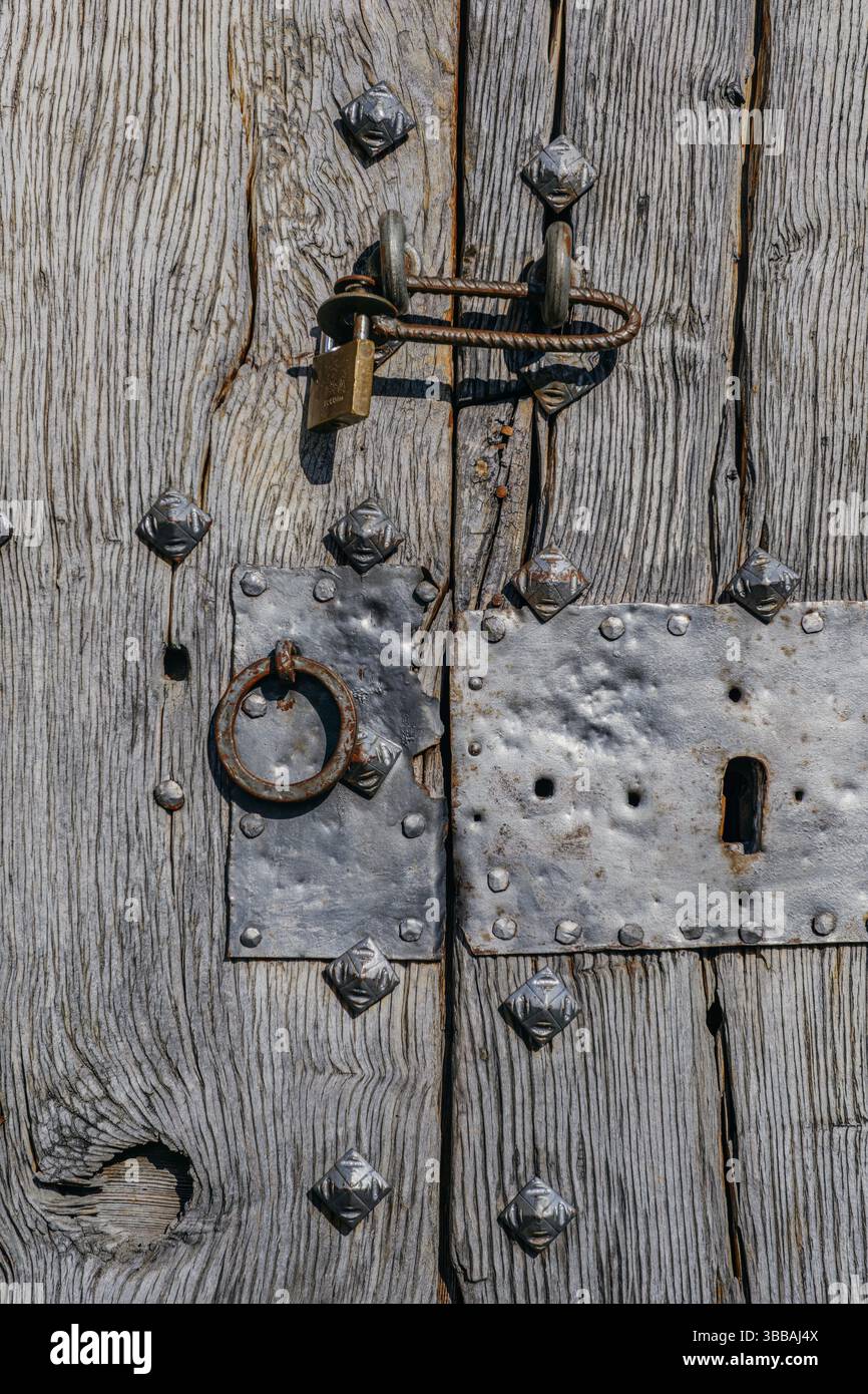 Ancient church door with decorative iron hardware in traditional stone ...