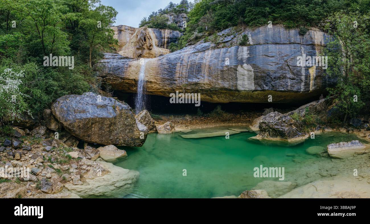 Hidden limestone grotto with waterfall and turquoise pool. Natural cave ...