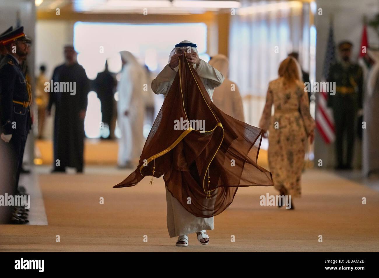 An official folds a "bisht" or traditional Arab cloak during ...