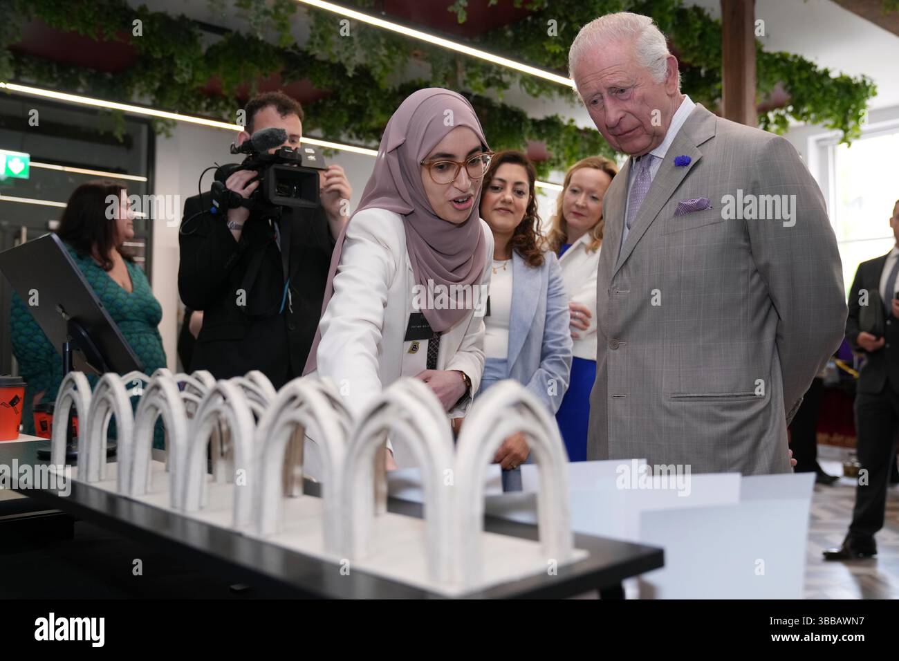 King Charles III speaks to staff members during a visit to Impact Hub ...