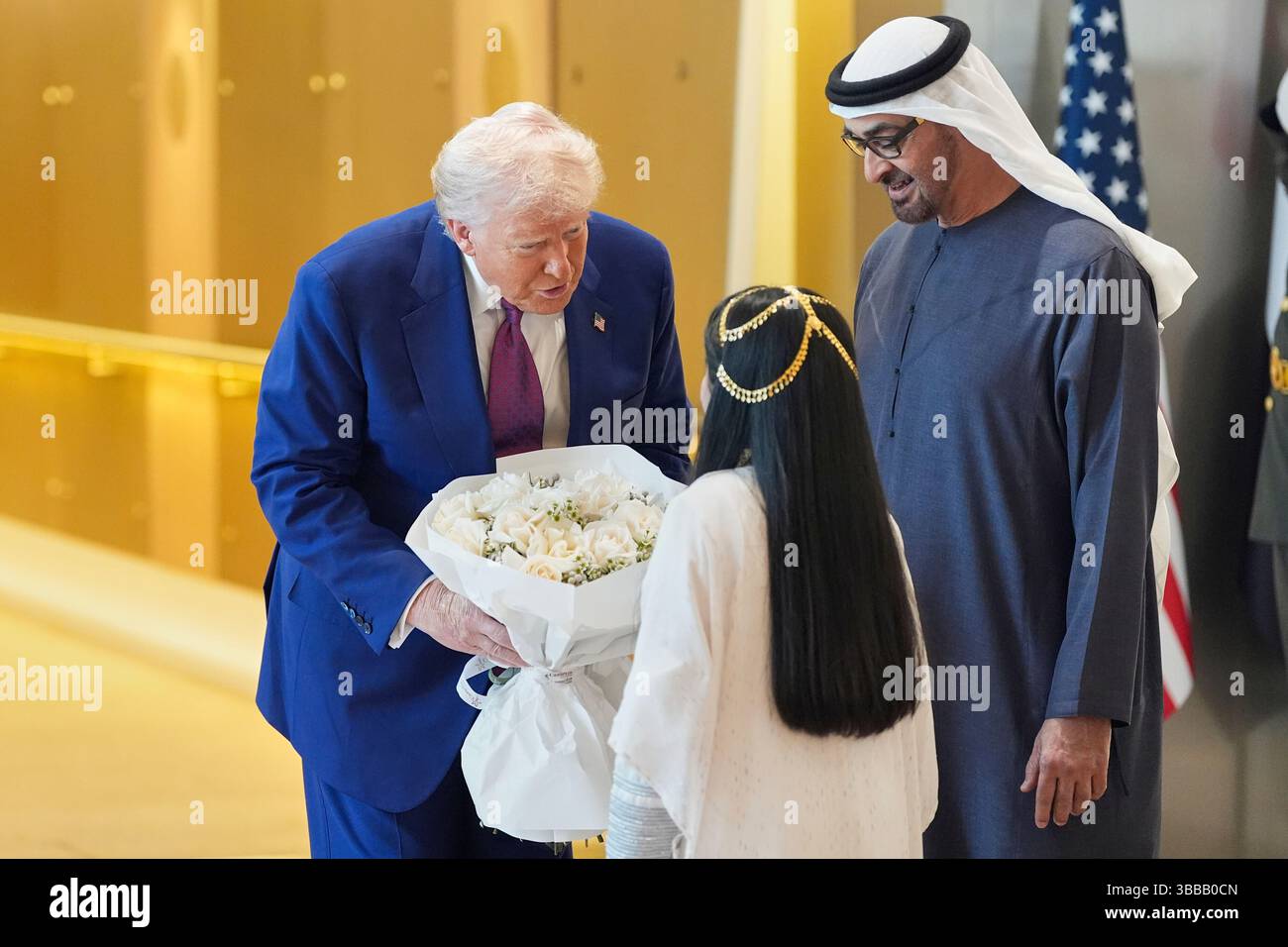 President Donald Trump receives flowers from a child next to UAE ...