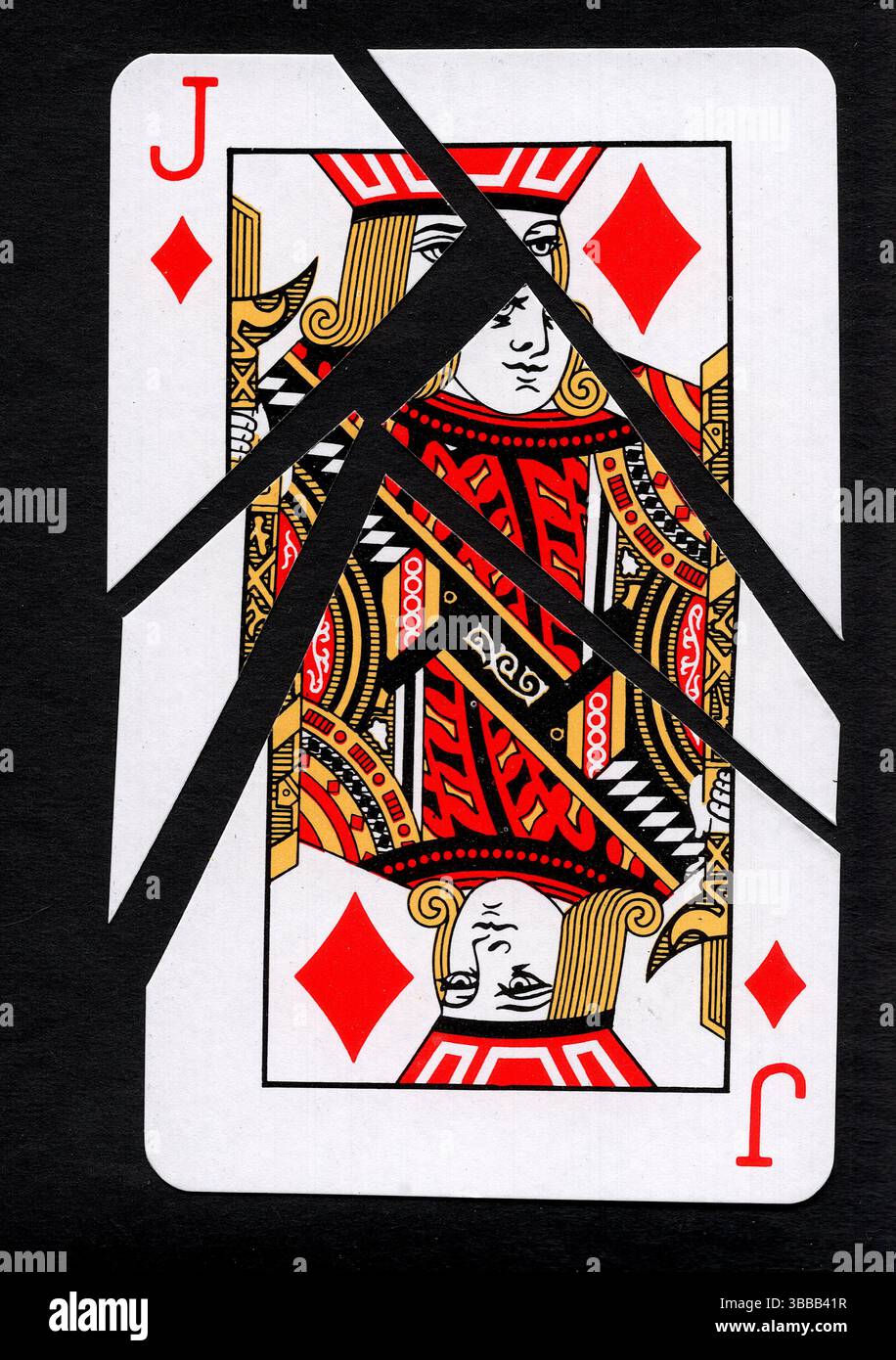 A vintage playing card cut into sharp pieces isolated on a black ...
