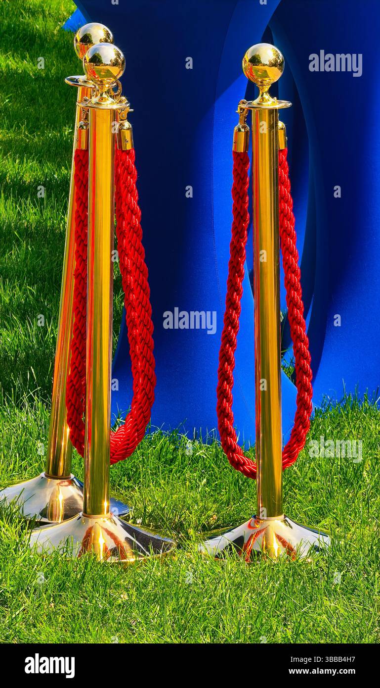 Elegant Event Setup with Golden Stanchions and Red Velvet Ropes on a ...