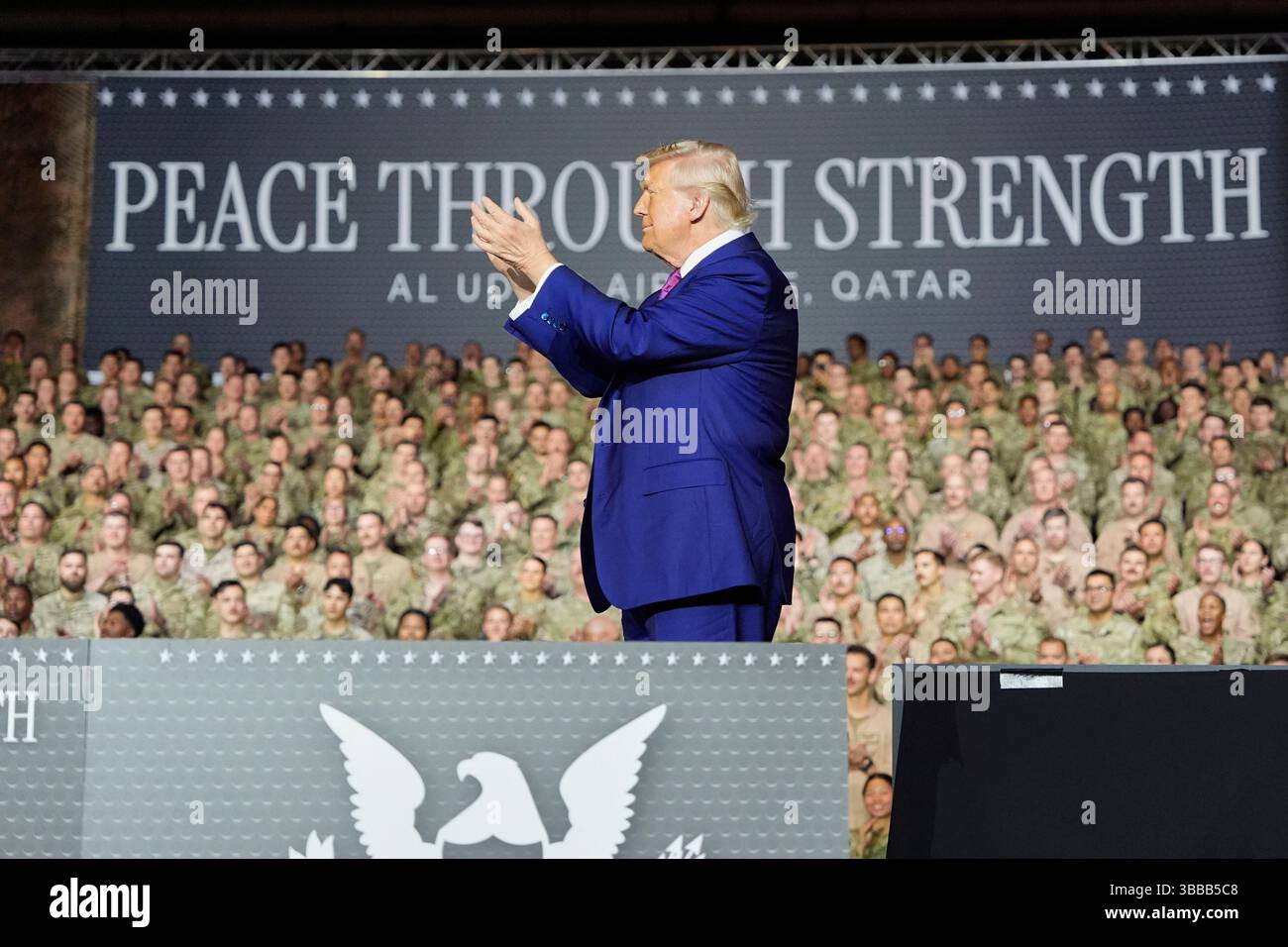 President Donald Trump applauds on stage at the Al Udeid Air Base ...