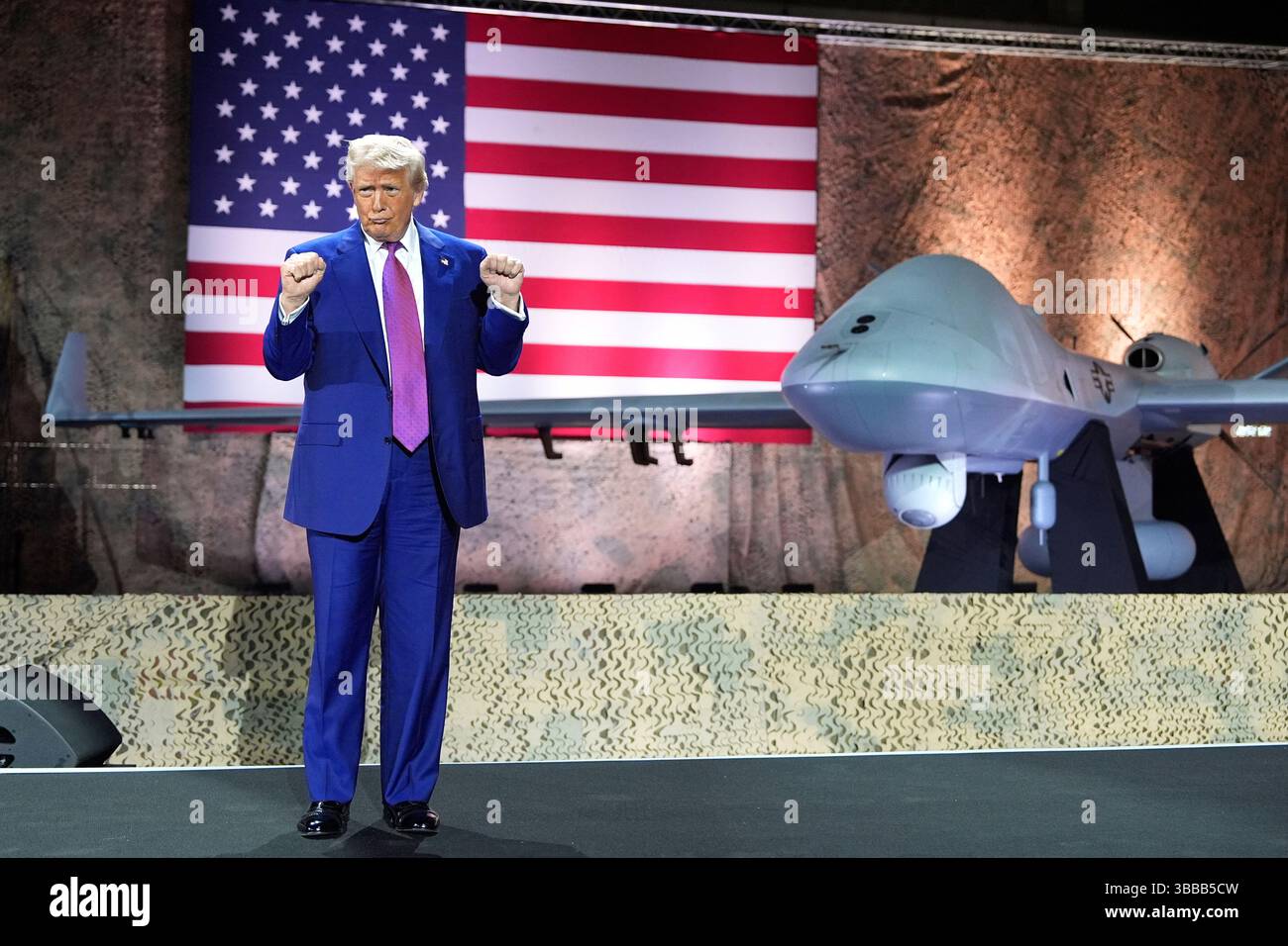 President Donald Trump gestures backdropped by an MQ-9 Reaper drone at ...