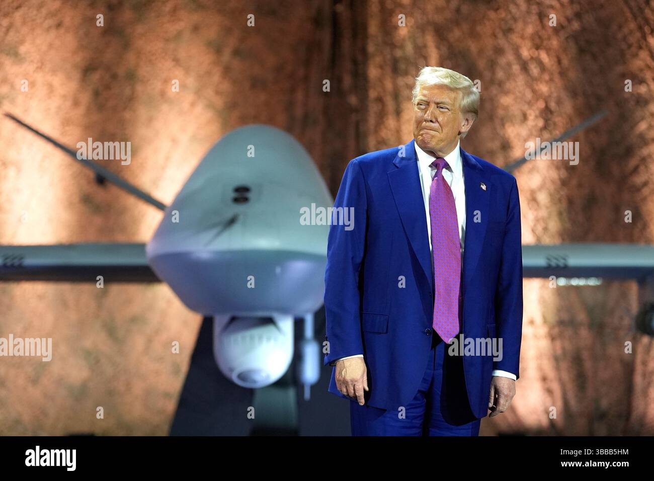 President Donald Trump stands backdropped by an MQ-9 Reaper drone before addressing military ...