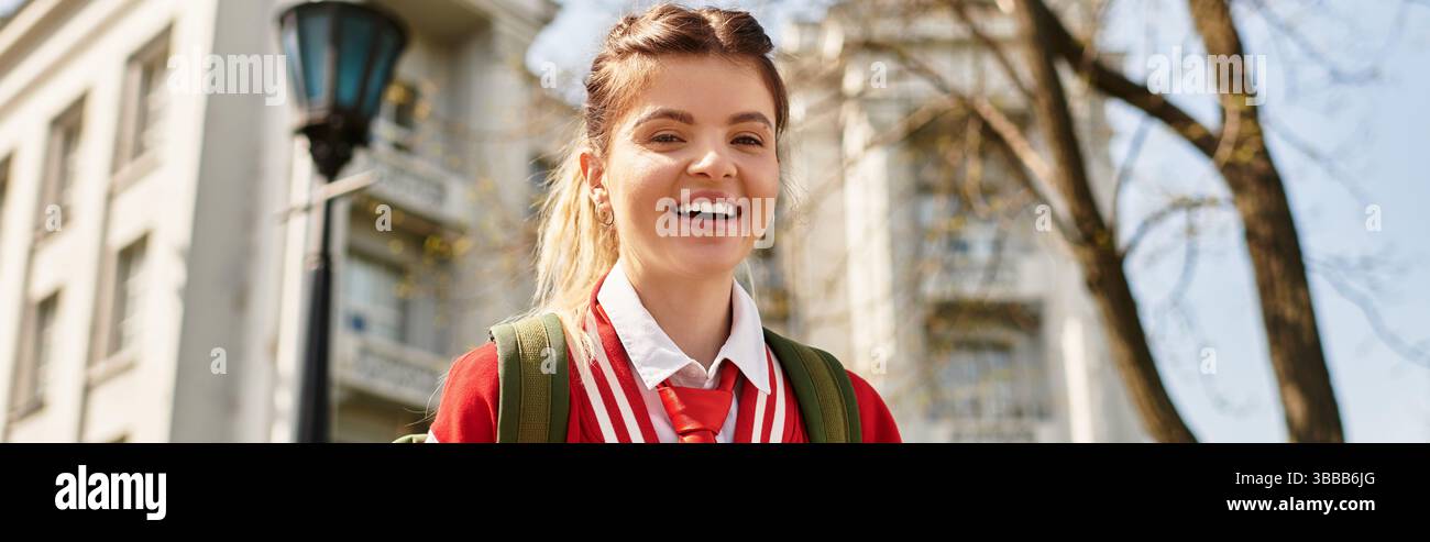 A young college student radiates joy as she walks on campus wearing a ...