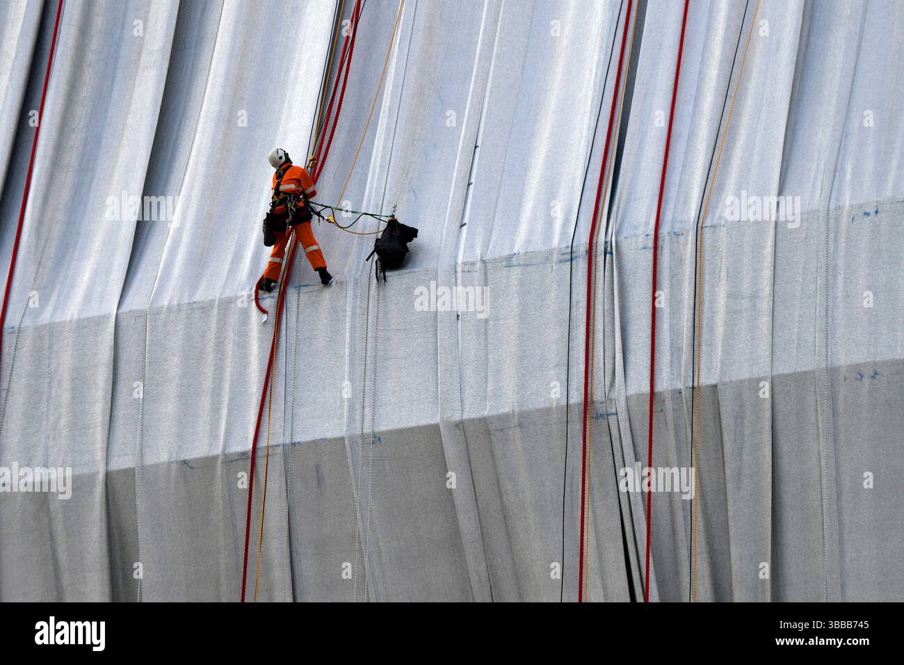 Workers install a shimmering wrapper to envelop Paris landmark, the Arc ...