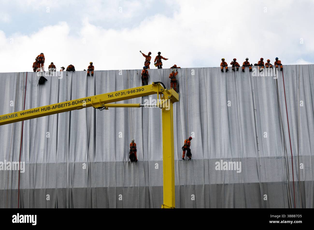 Workers install a shimmering wrapper to envelop Paris landmark, the Arc ...