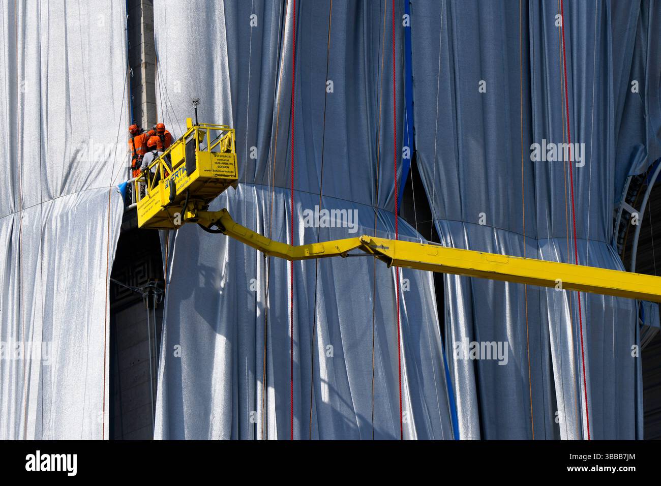 Workers install a shimmering wrapper to envelop Paris landmark, the Arc ...