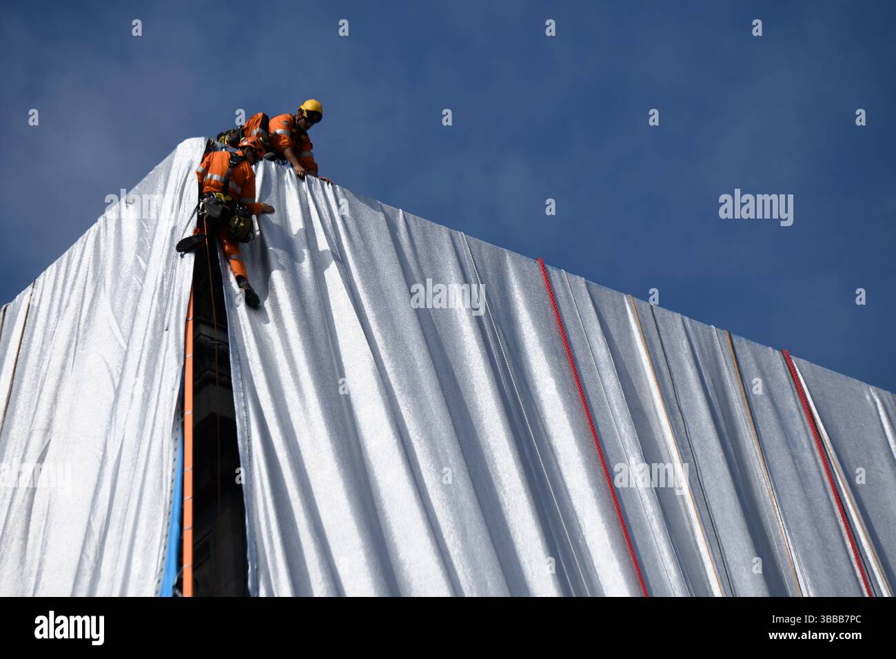 Workers install a shimmering wrapper to envelop Paris landmark, the Arc ...