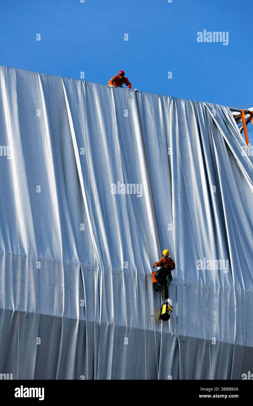 Workers install a shimmering wrapper to envelop Paris landmark, the Arc ...