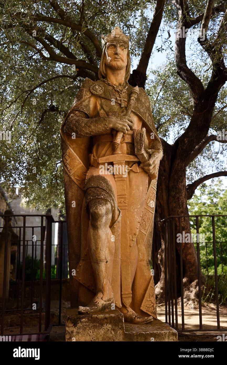 Statue of King Alfonso X or Fernando III nest to the Tower of the Lions ...