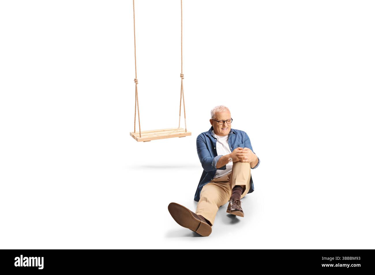 Man with an injured knee falling from a swing and sitting on the ground ...