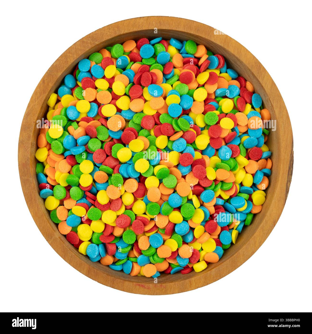 Top view of round cake sprinkles in a small wood bowl on a white ...