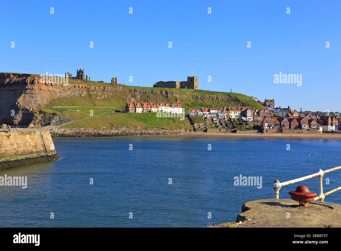 Whitby harbour entrance with St Mary's Church and Whitby Abbey on East ...