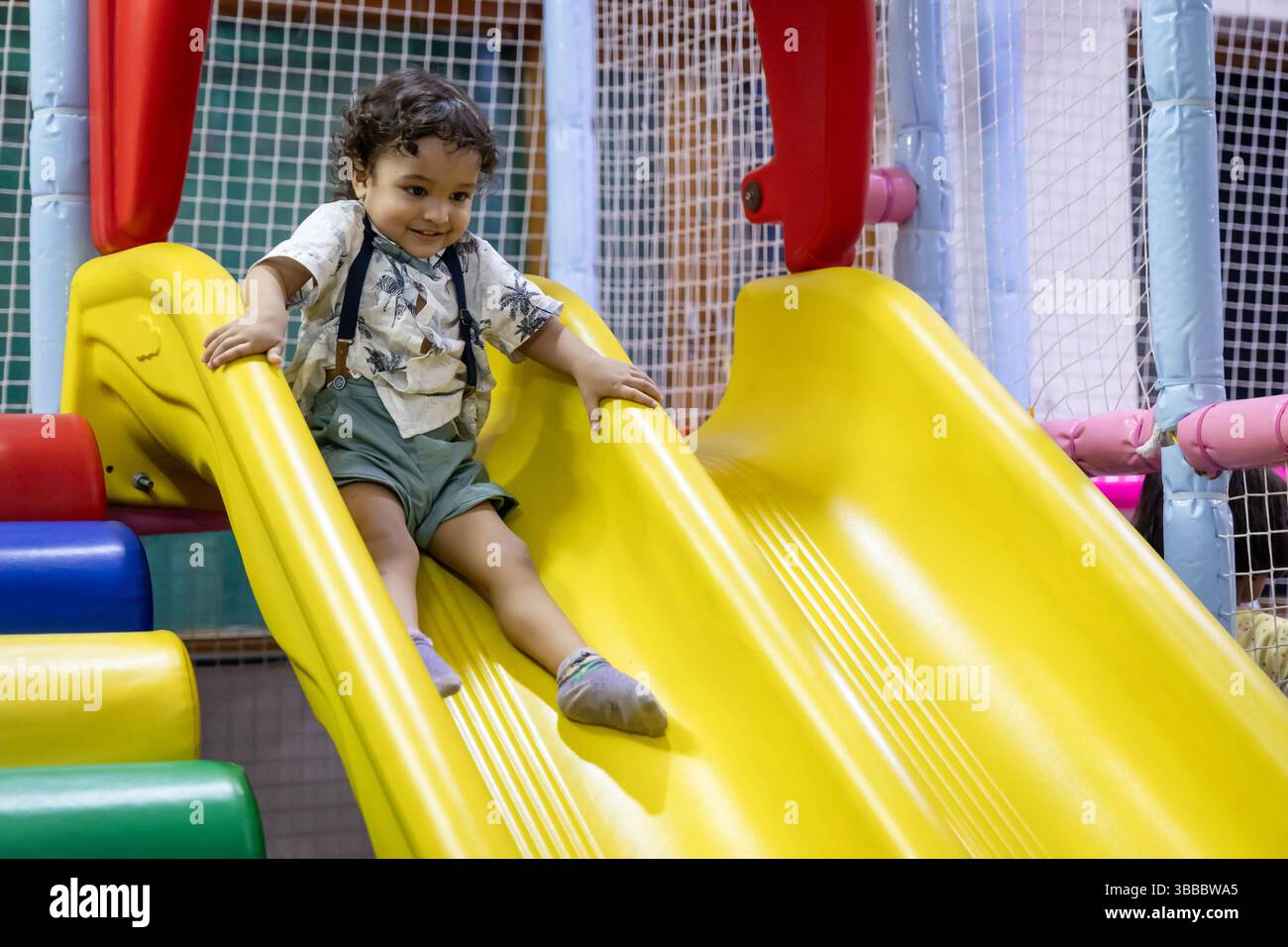 adorable baby boy enjoying while sliding at indoor kids play area Stock ...