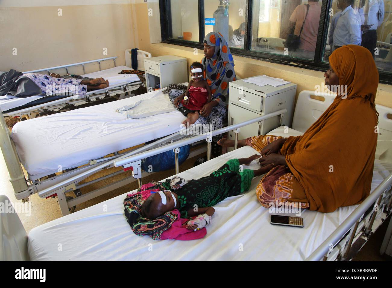 Women sit with malnourished children at Banadir Hospital in Mogadishu ...
