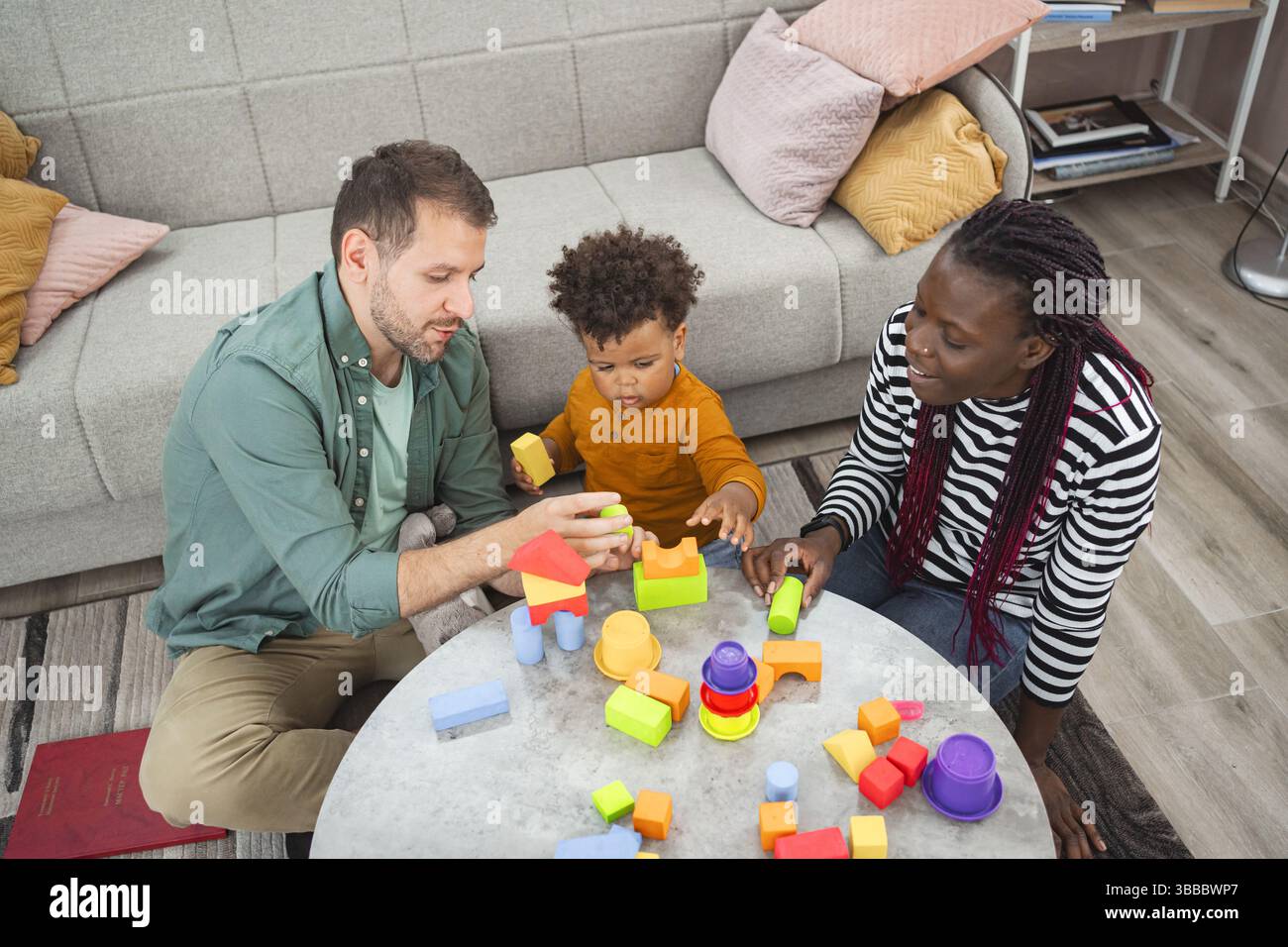 Multiracial family playing with colorful blocks in their living room ...