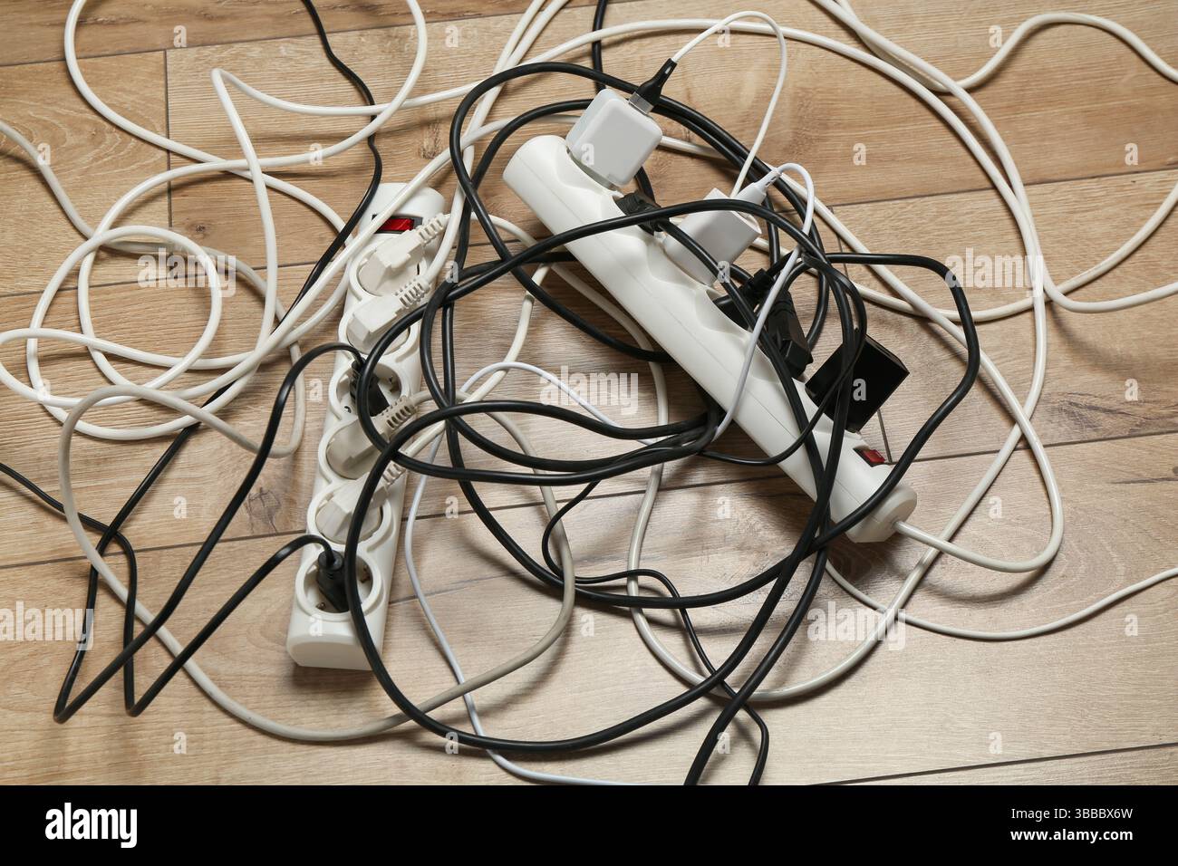Extension power boards overloaded with plugs on wooden floor Stock ...