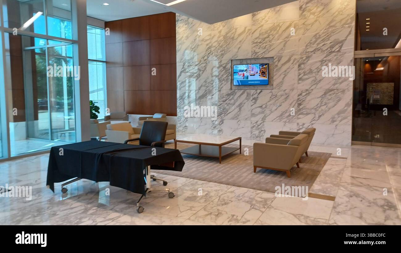 Charlotte, NC, USA – April 29, 2025: A modern building lobby looks out ...