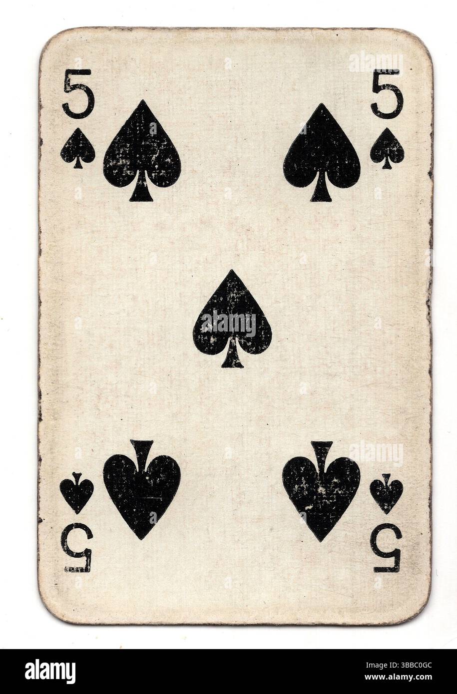 A vintage playing card in the suit of spades isolated on a white ...