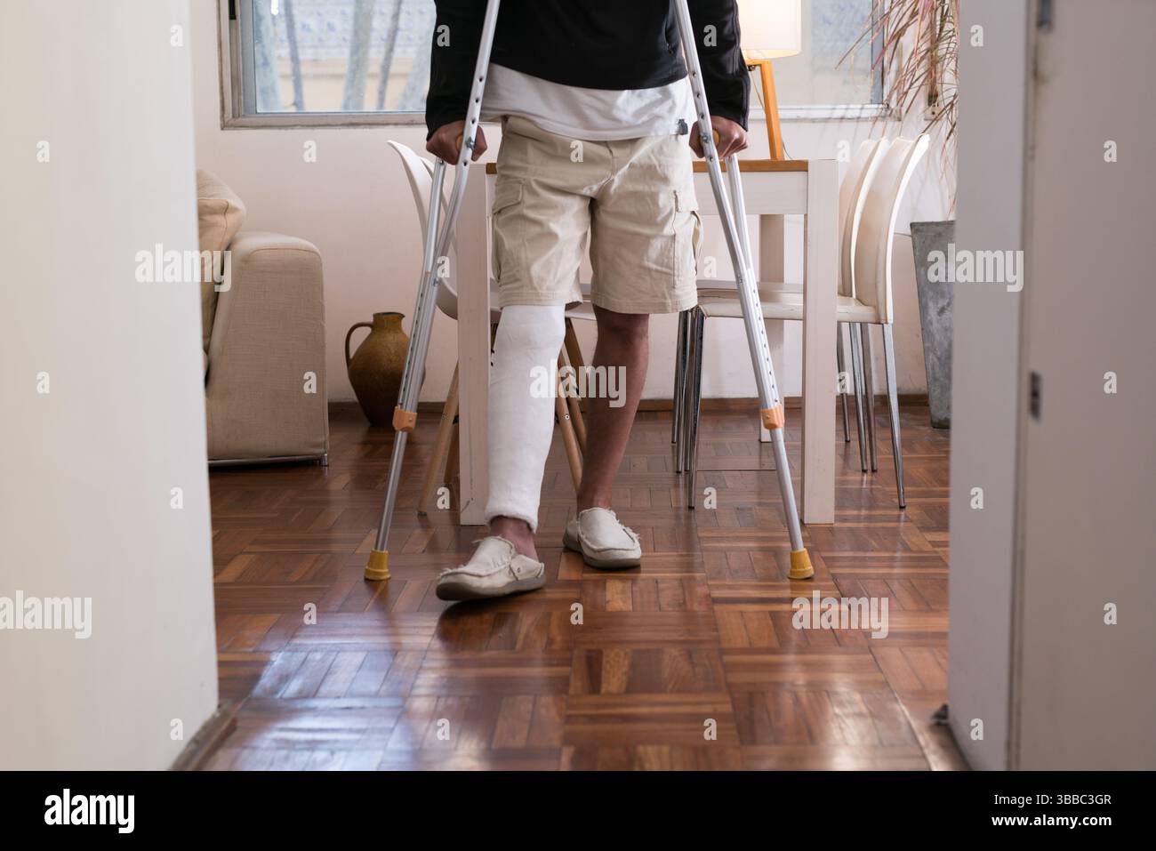 Patient using crutches to walk at home after having his leg in a cast ...