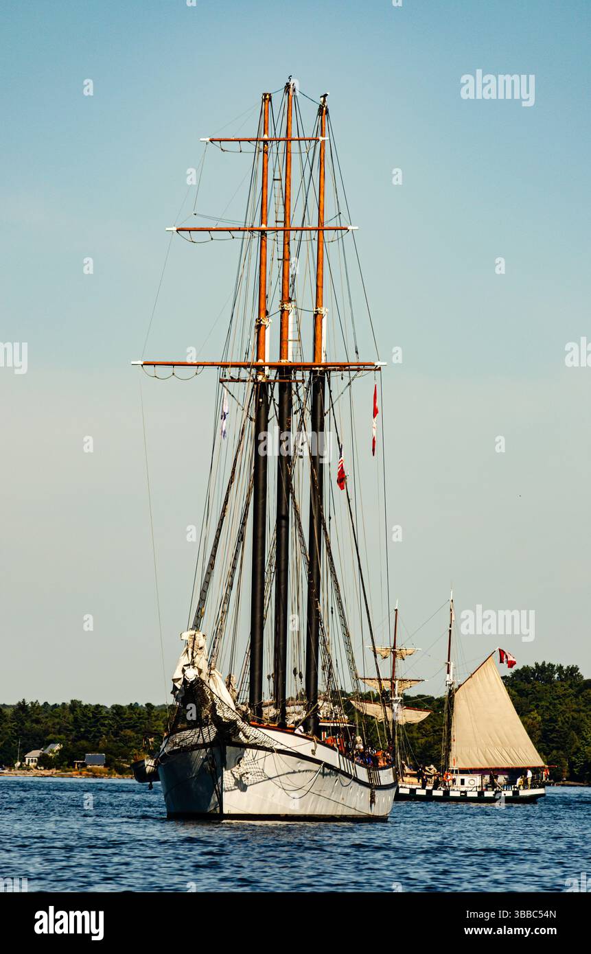Vertical frame of two tall ships, one in full sail on the St. Lawrence ...