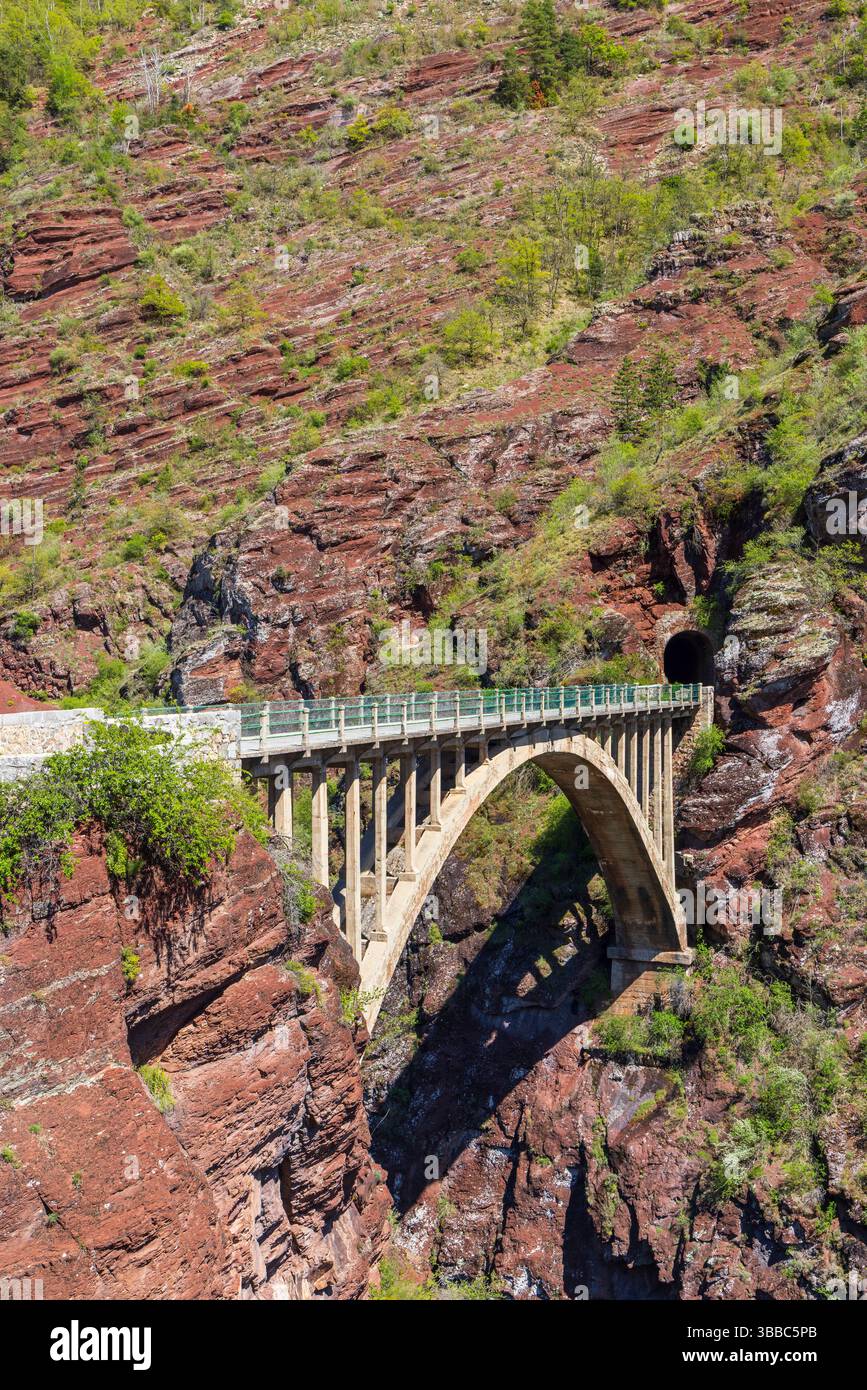 Concrete bridge crossing red rocks in the Gorges Rouges, near ...