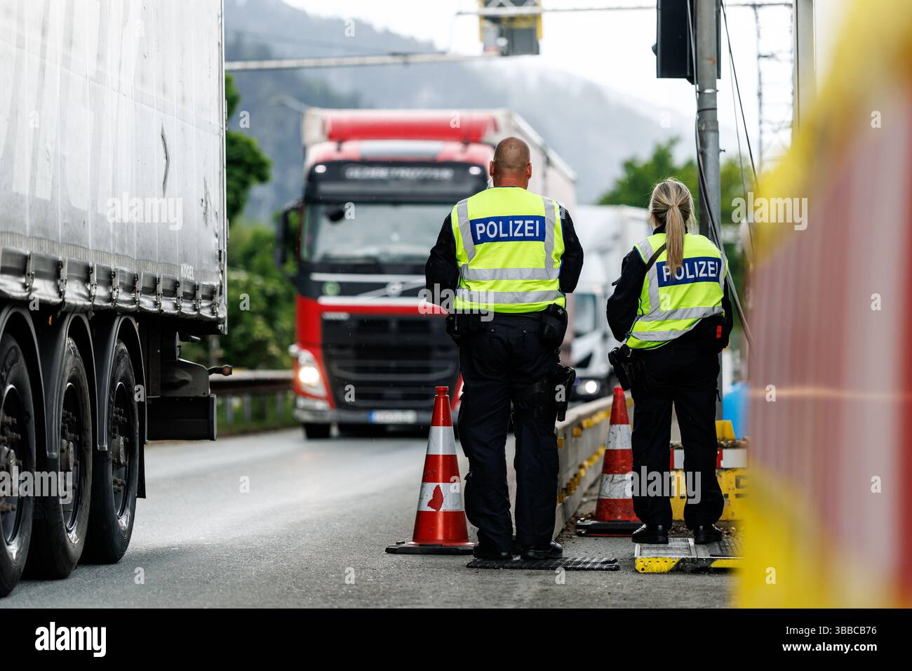 15 May 2025, Bavaria, Kiefersfelden: Two police officers stand on the ...
