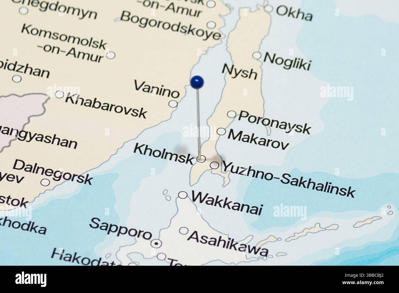 macro photo of a blue pin needle into kholmsk city of Russia political ...