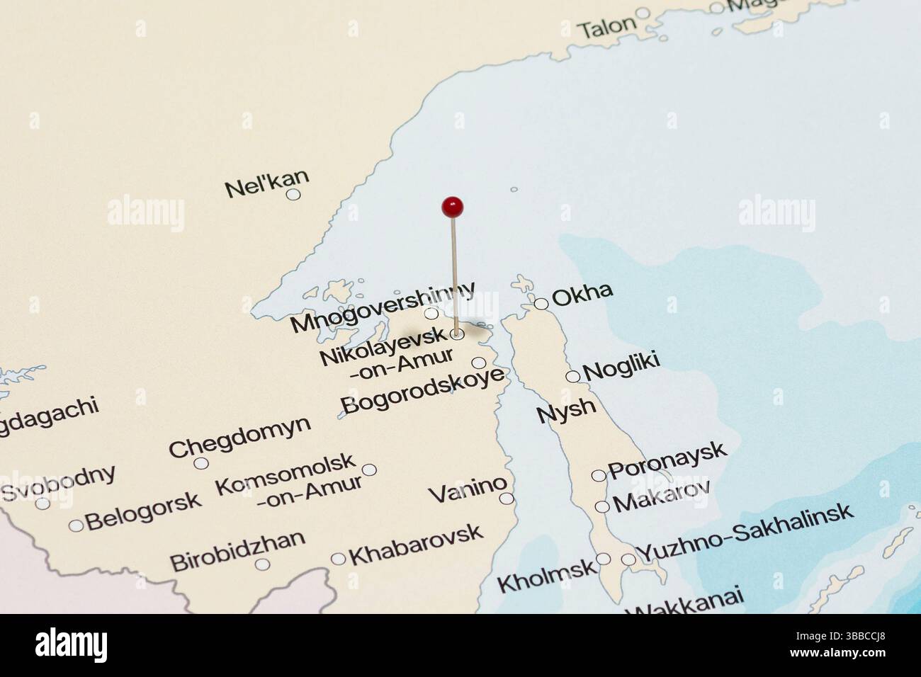 macro photo of a red pin needle into nikolayevsk-on-amur city of Russia ...