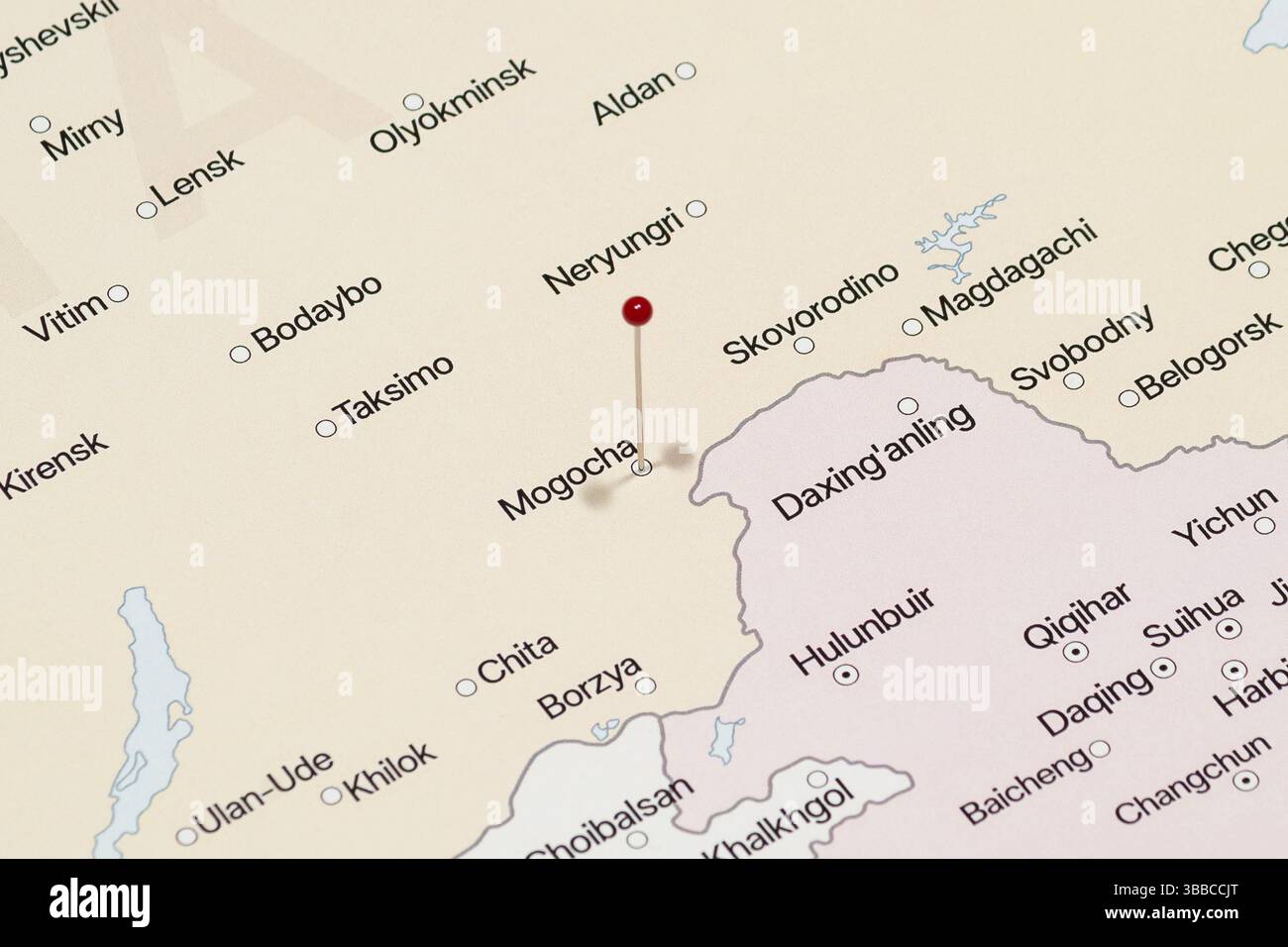macro photo of a red pin needle into mogocha city of Russia political ...
