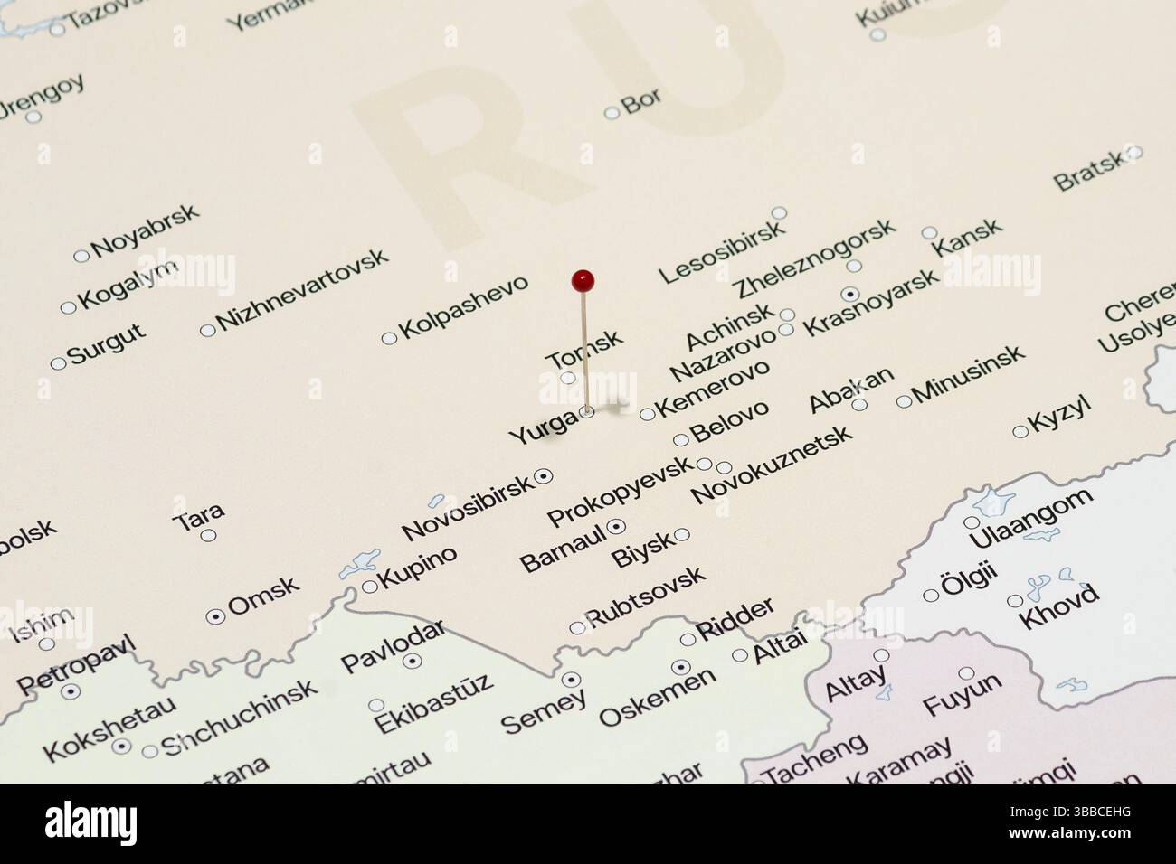 macro photo of a red pin needle into yurga city of Russia political map ...