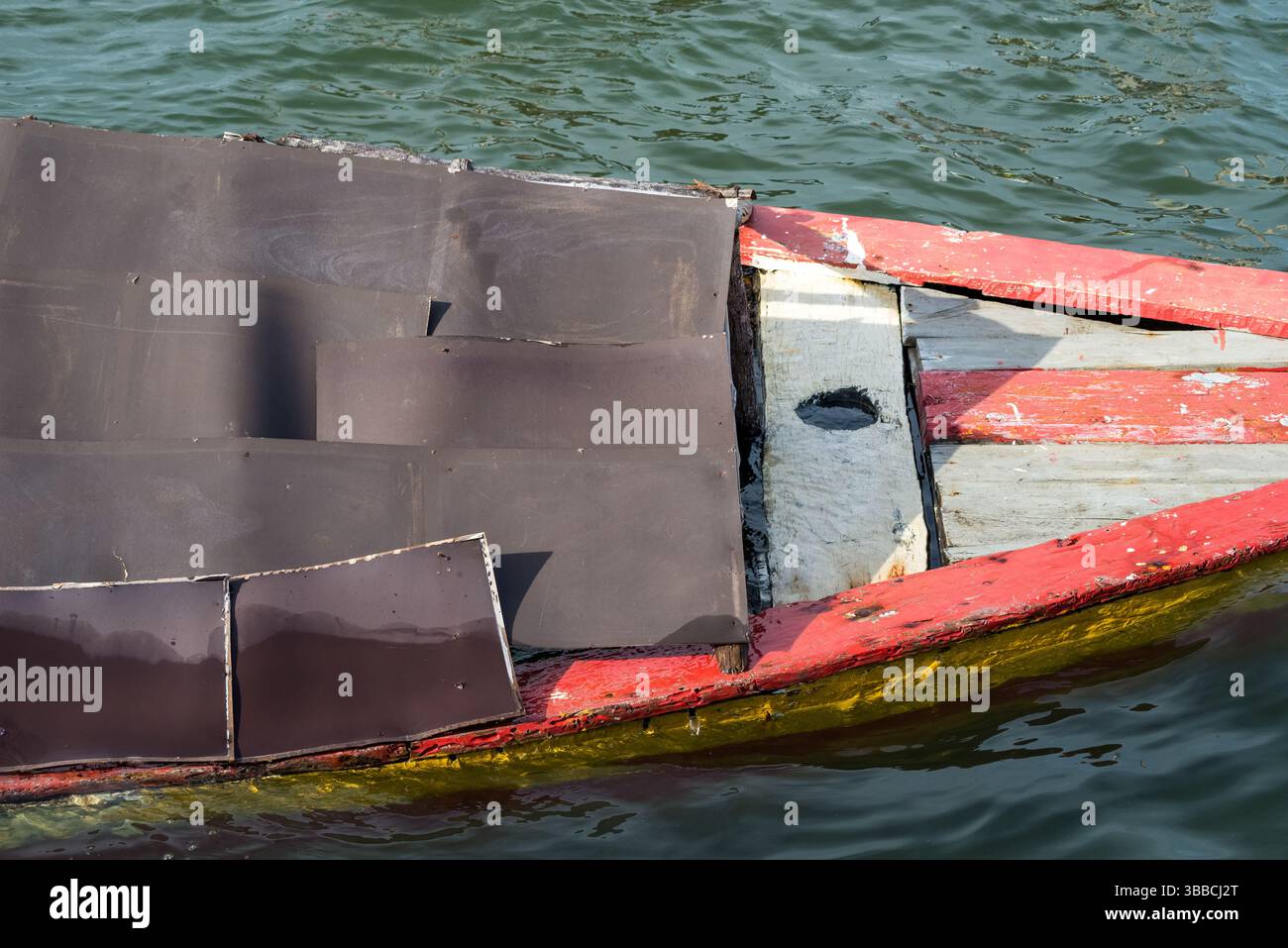 View of the remains of an abandoned wooden boat half sunk in a river ...