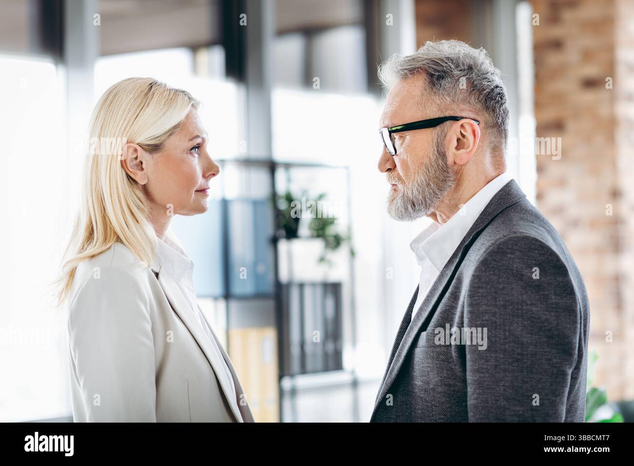 Professional business partners having focused conversation in a modern ...