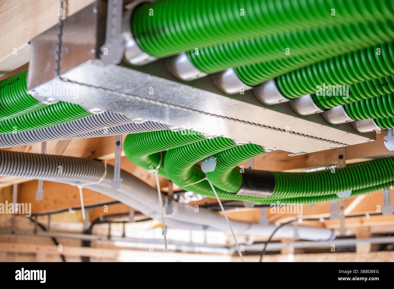 Intricate ductwork in vibrant green color is installed overhead within ...