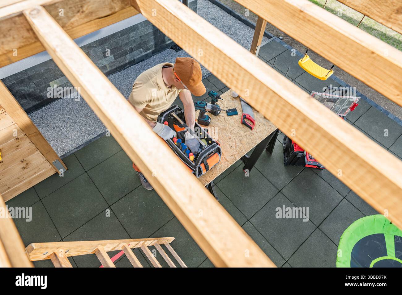 A construction worker is focused on arranging various tools within a ...