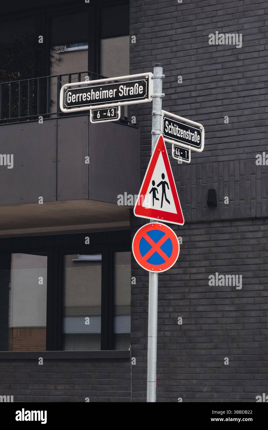 Warning and directional road sign in front of black bricked building ...