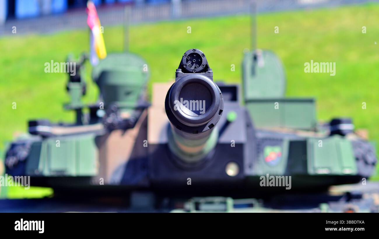 Heavy military tank vehicle turret gun aiming on a target and ready to fire. The rotating turret ...