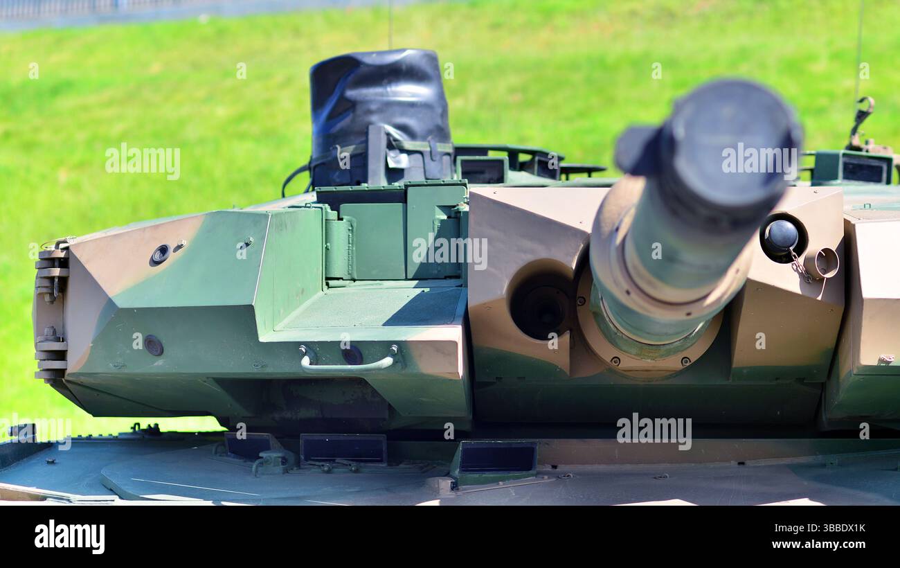 Heavy military tank vehicle turret gun aiming on a target and ready to fire. The rotating turret ...