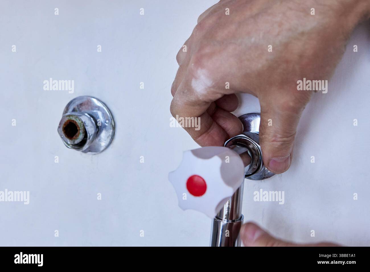 Hands carefully connect new dual handle faucet to exposed plumbing ...