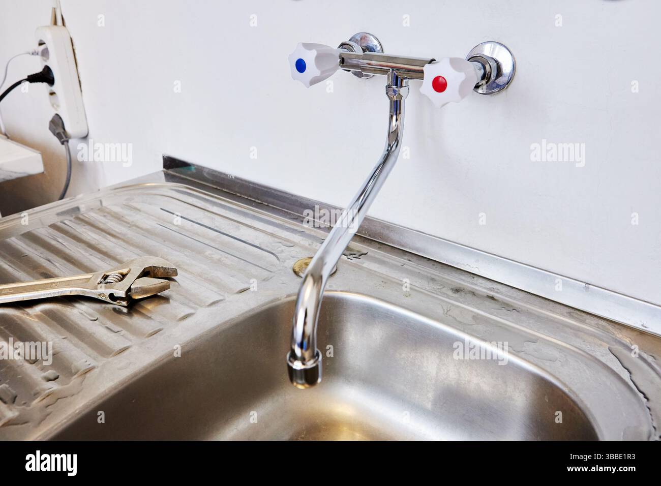 Wall mounted faucet with blue and red knobs, is fully assembled above ...