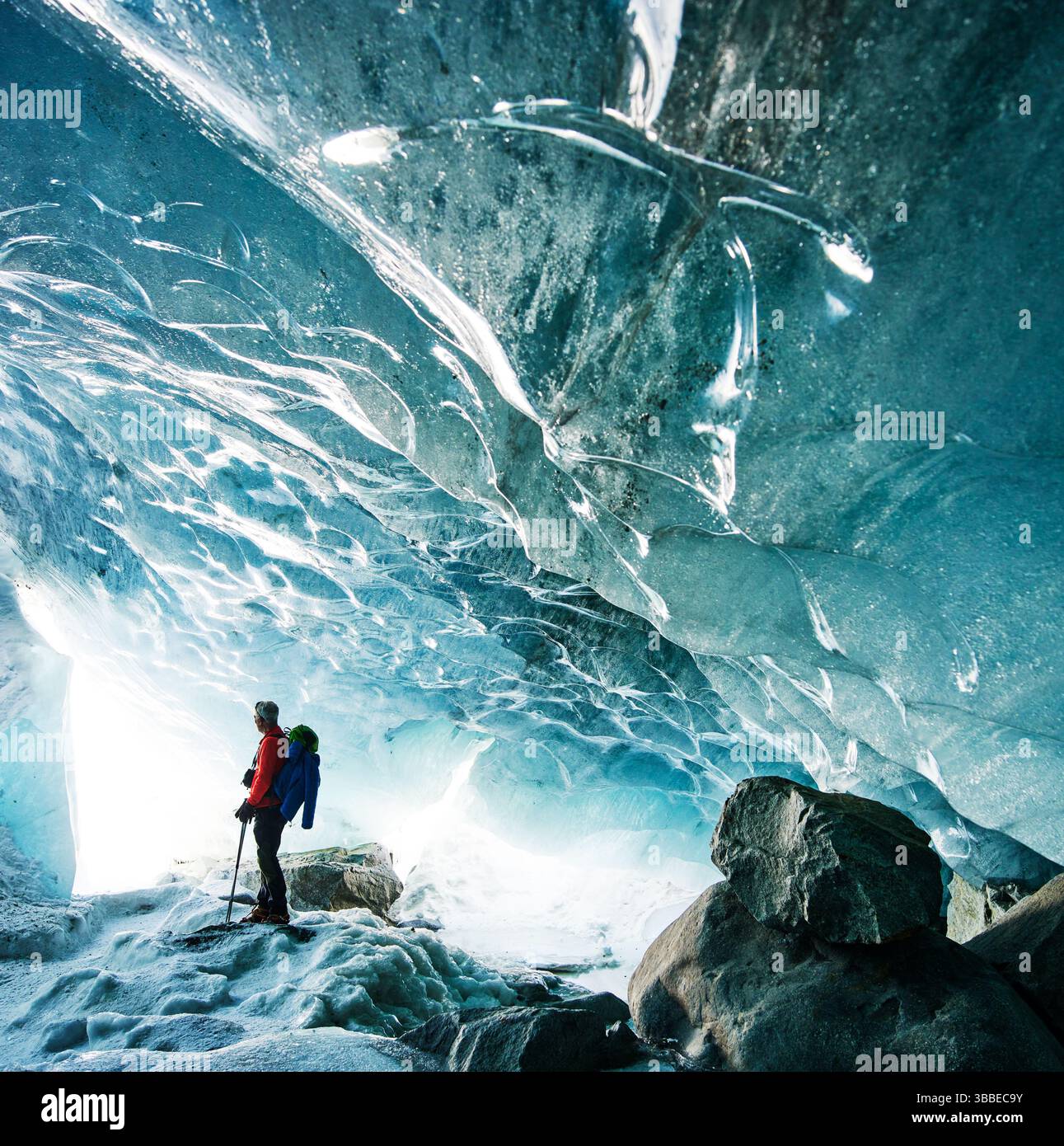 Hiker walking through Morteratsch Glacier Ice Caves, Switzerland ...