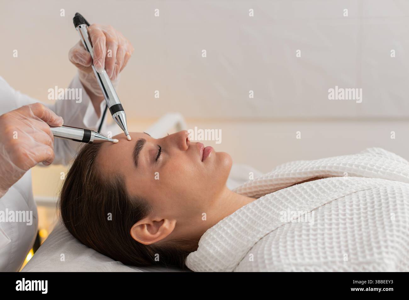 Cosmetologist doctor makes woman micro currents face forehead therapy ...