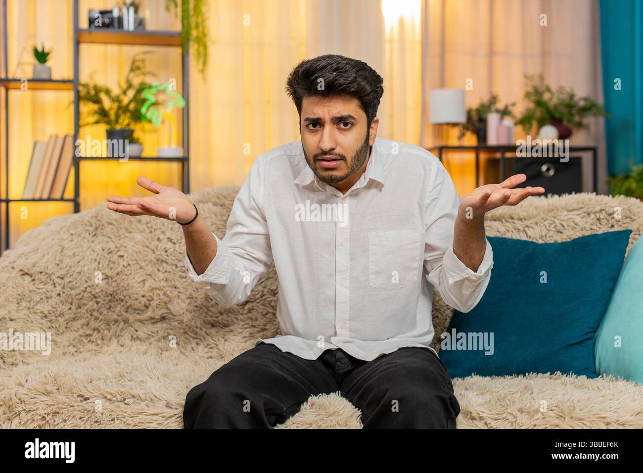 Indian man at home looking surprised, raising hands in a what why ...