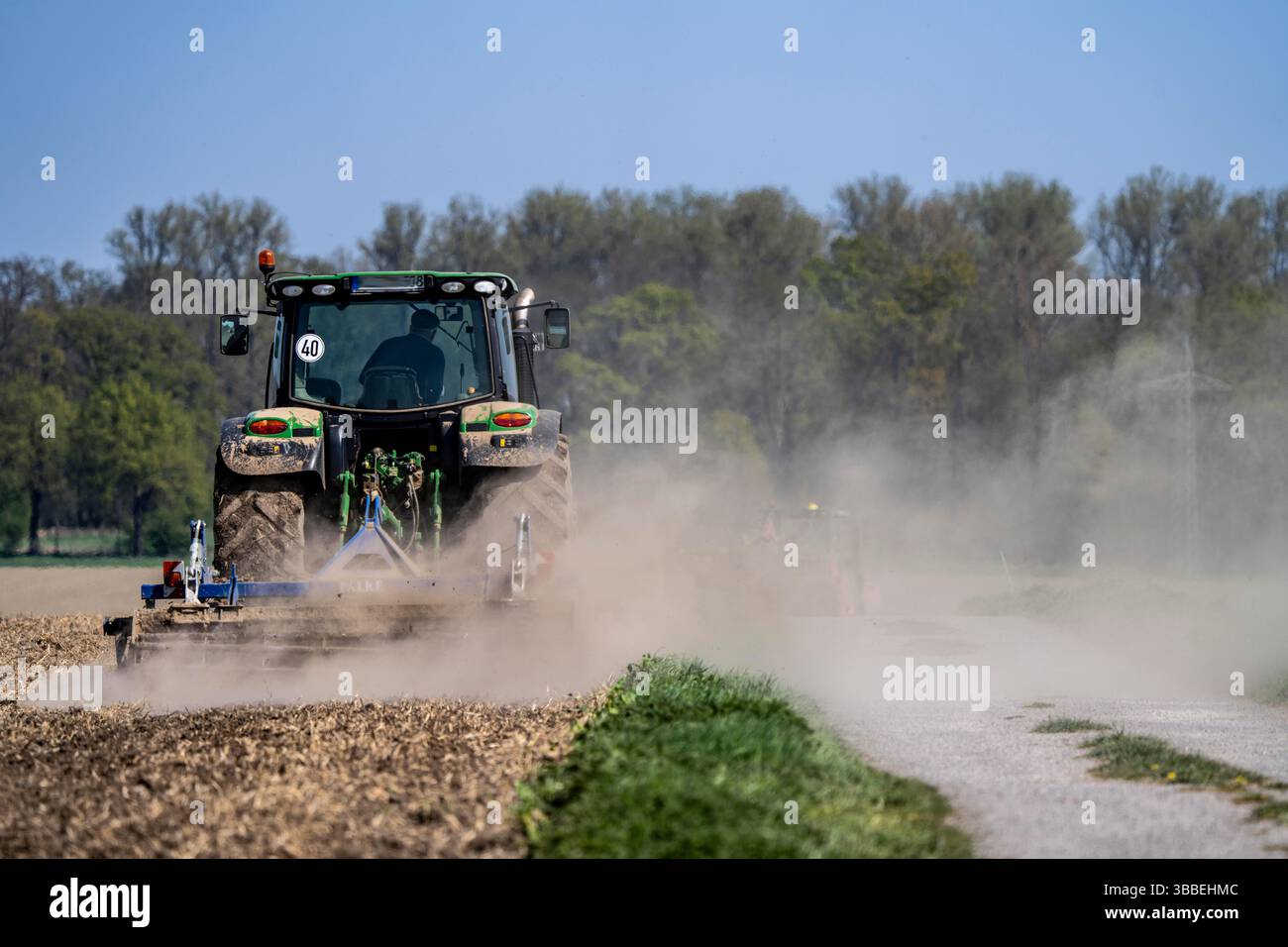 A tractor works a field. Due to a long dry spell in spring, with no ...